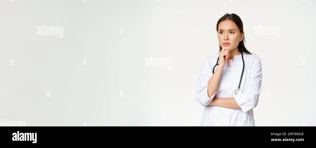 Image of serious doctor, female healthcare worker thinking, looking ...