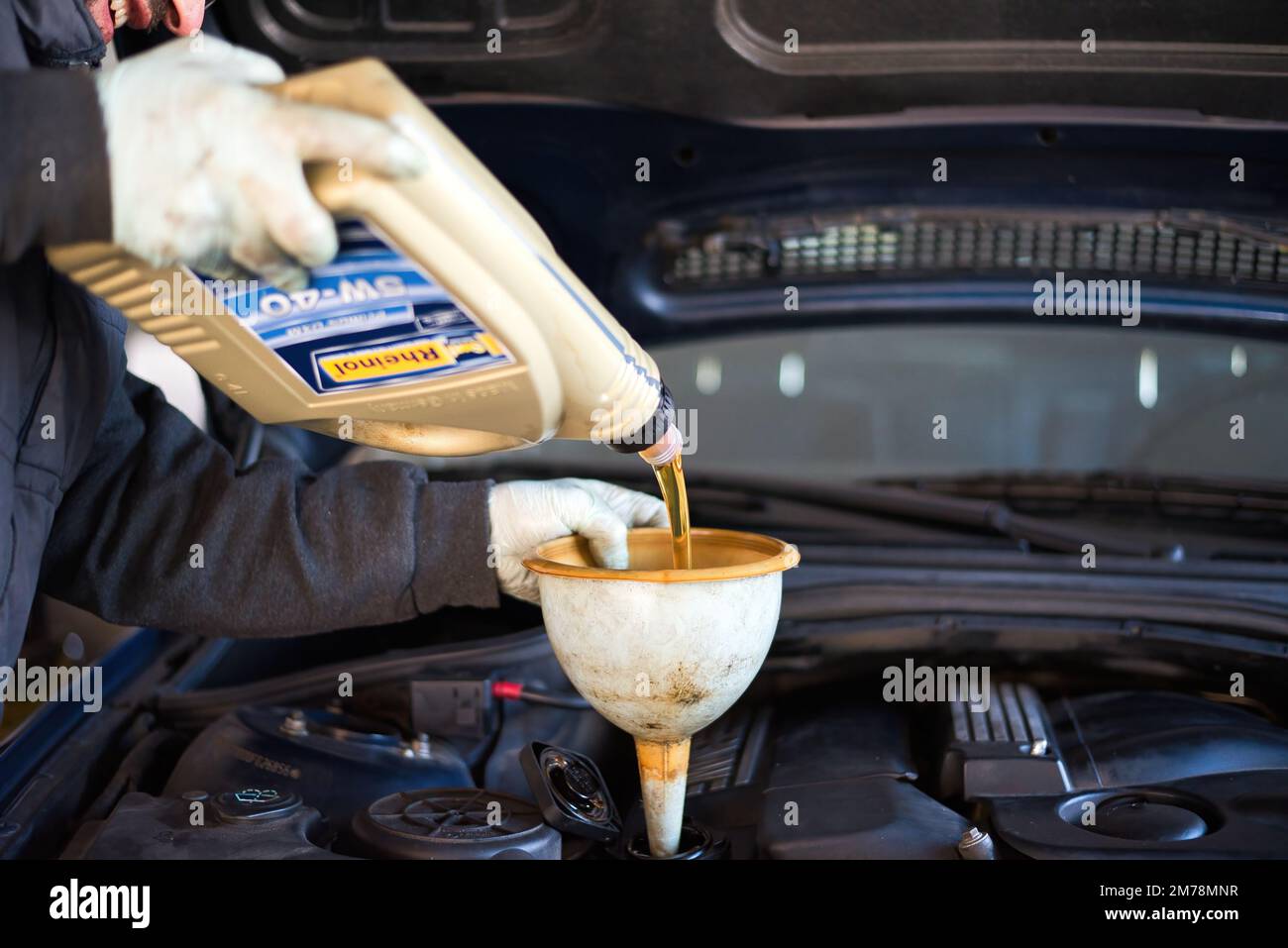 work in a garage , worker controls and changes the motoroil Stock Photo ...