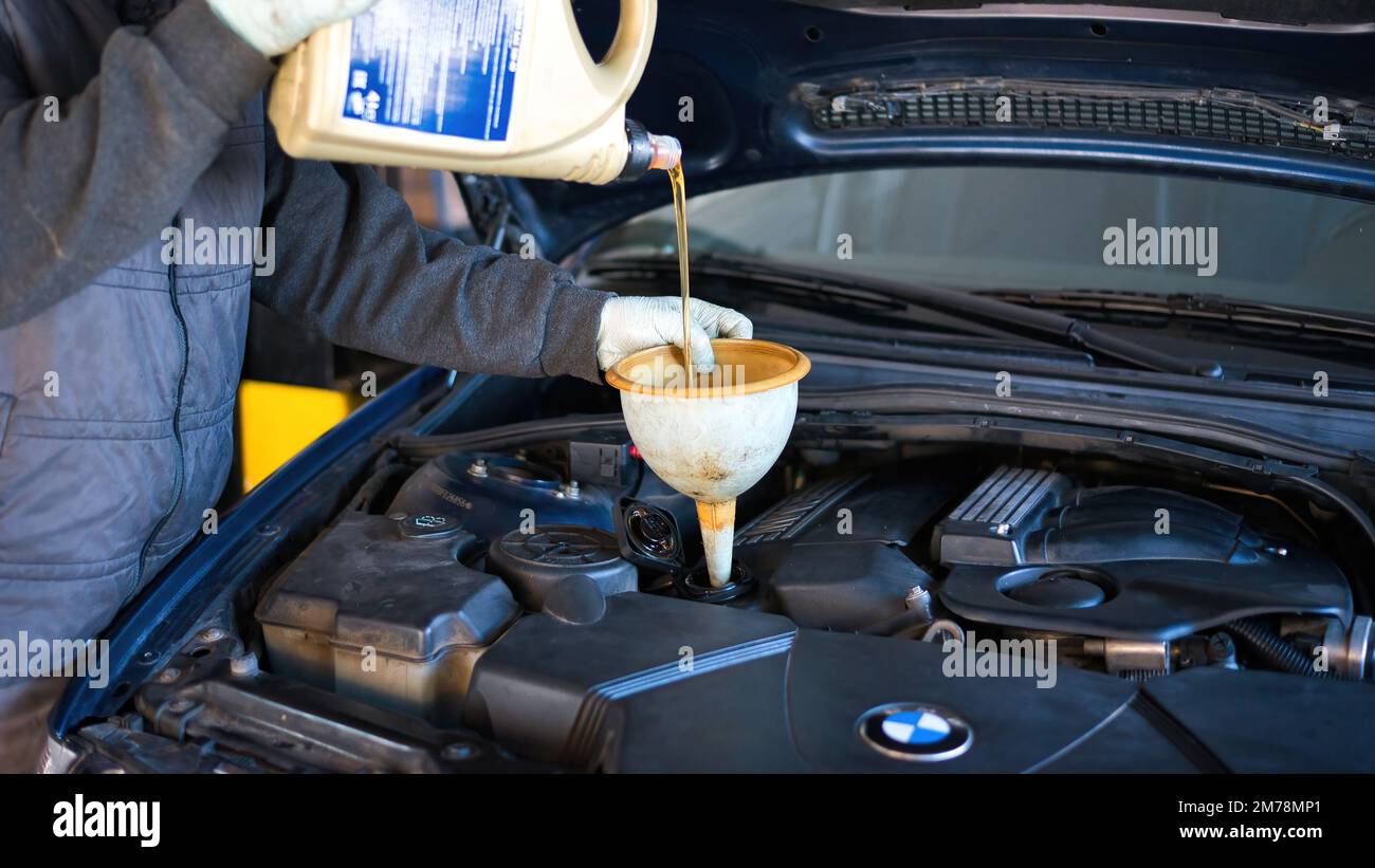 work in a garage , worker controls and changes the motoroil Stock Photo ...