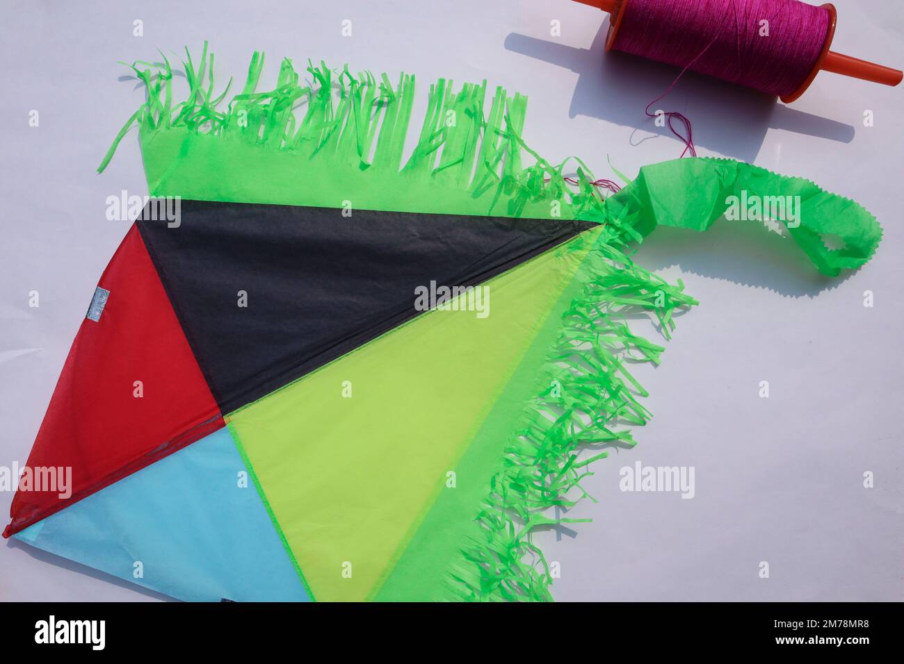 Colour kite with spool on white background Stock Photo - Alamy