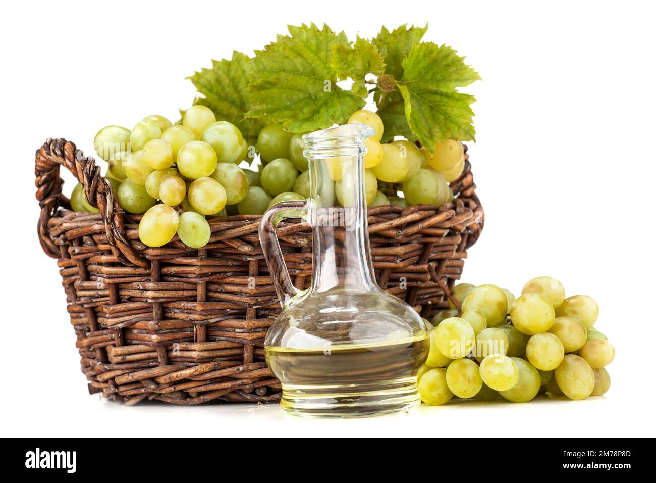 Grape seed oil on white background. The image also shows light grapes ...