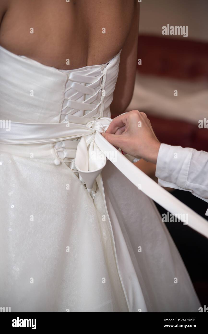 tying the wedding dress of the young bride before the ceremony Stock ...