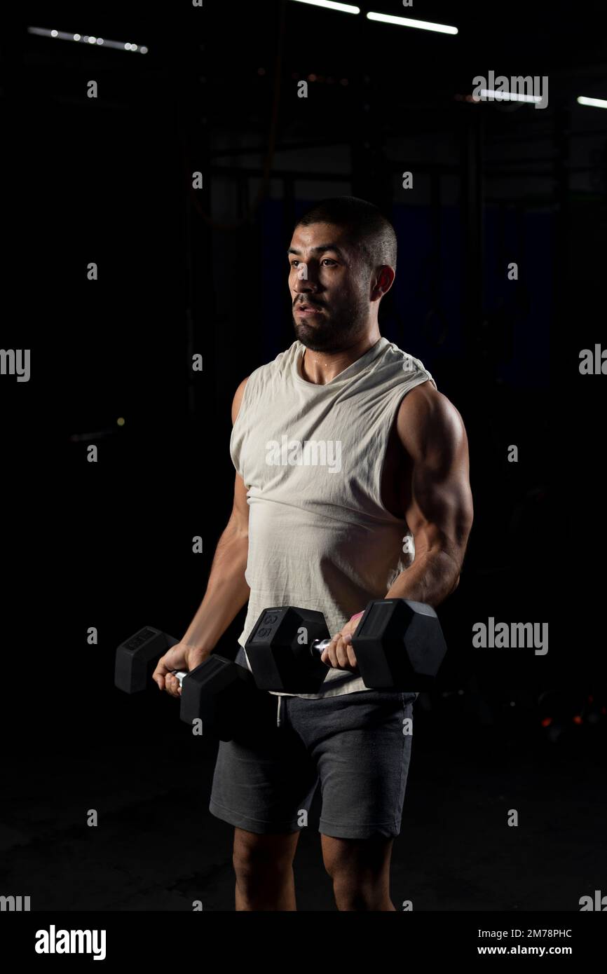 latin man doing biceps work in the gym with two dumbbells Stock Photo ...