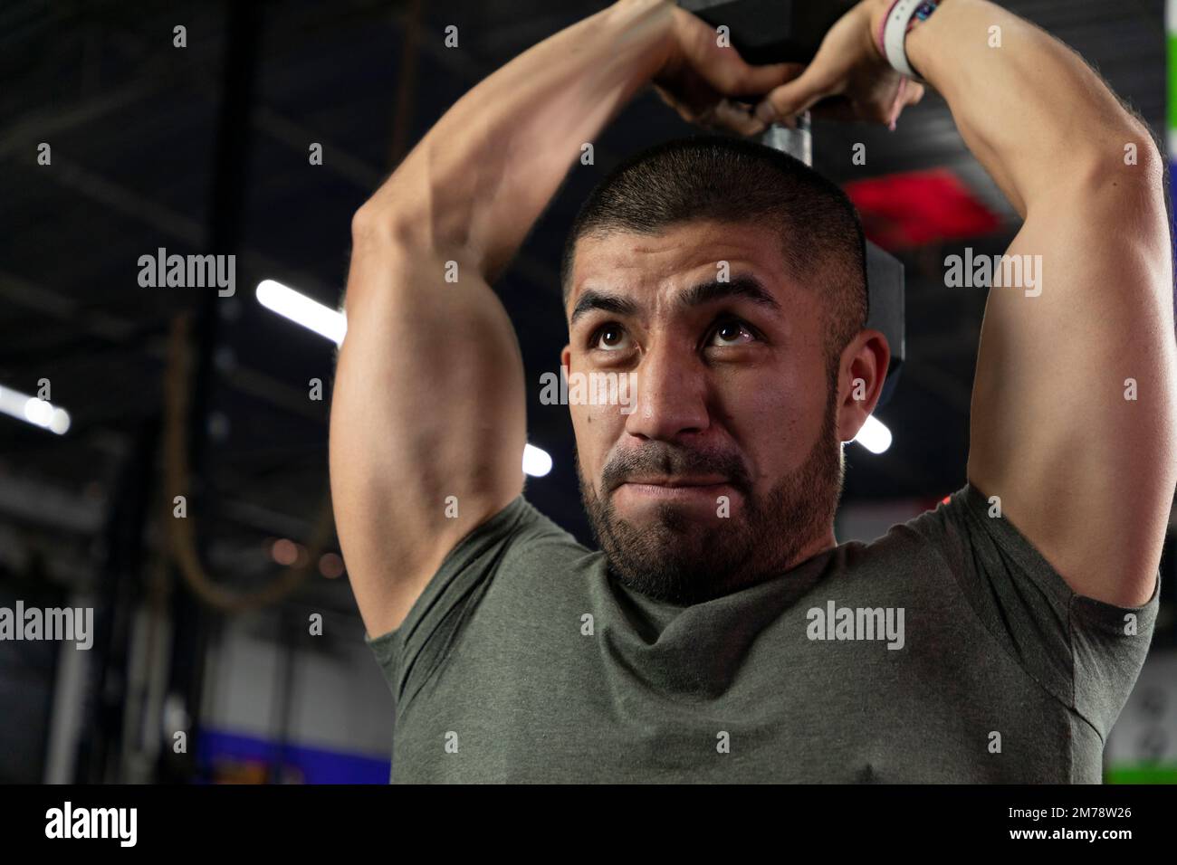 close up of a latino athlete doing triceps exercise in a gym with a ...