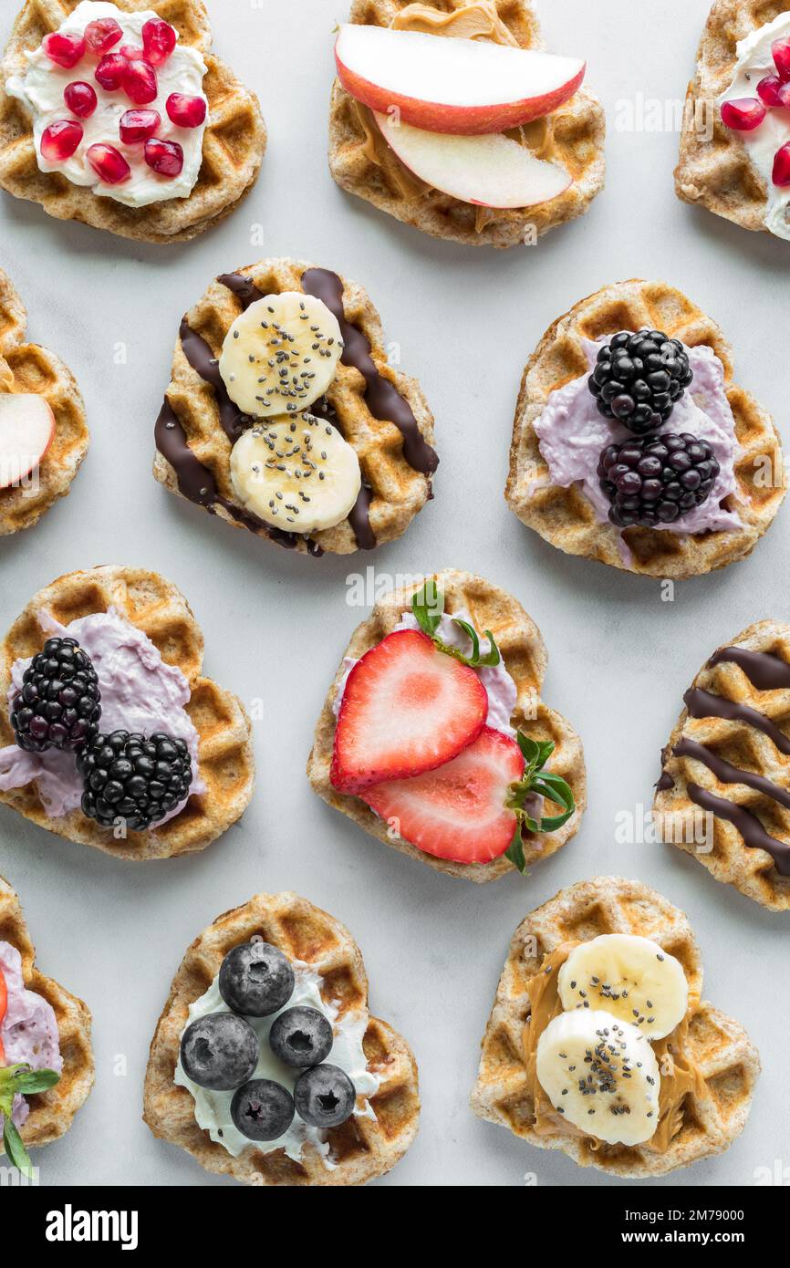 Mini heart shaped waffles with various toppings of spreads and fruit ...