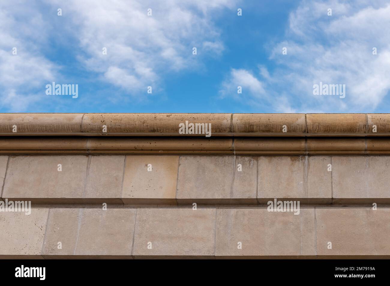 Stone wall made of dolomite against the blue sky. Rustication and ...