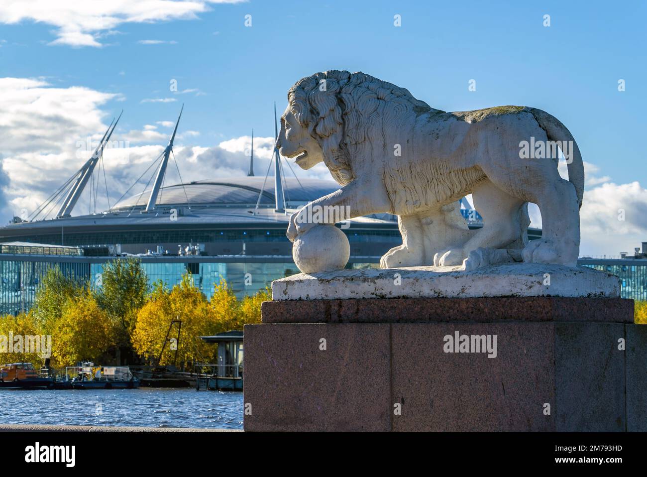 Sculpture of a lion with a ball on the background of the Zenit Arena ...