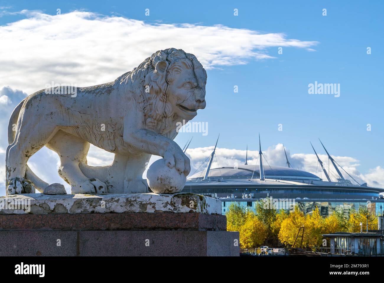 Sculpture of a lion with a ball on the background of the Zenit Arena ...