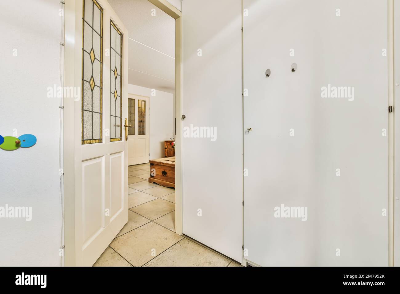 an empty hallway with white walls and tile flooring on the right side ...