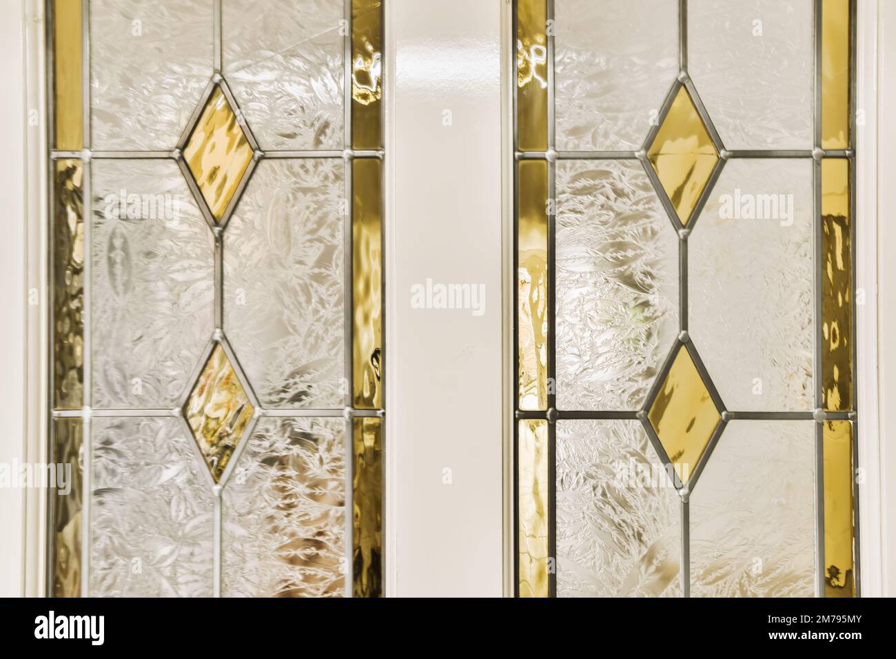 two glass doors with gold and white designs on the front, one door is ...