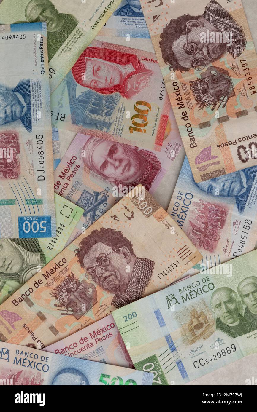 Vertical image of Mexican pesos bills of various denominations on a ...