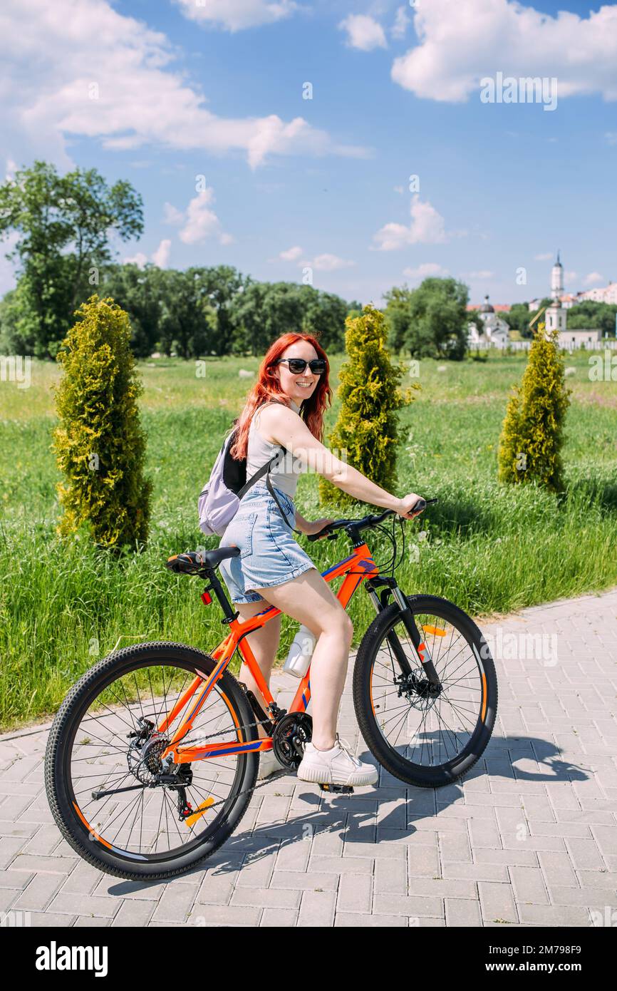 Young woman in the city rides bike and leads an active lifestyle doing ...