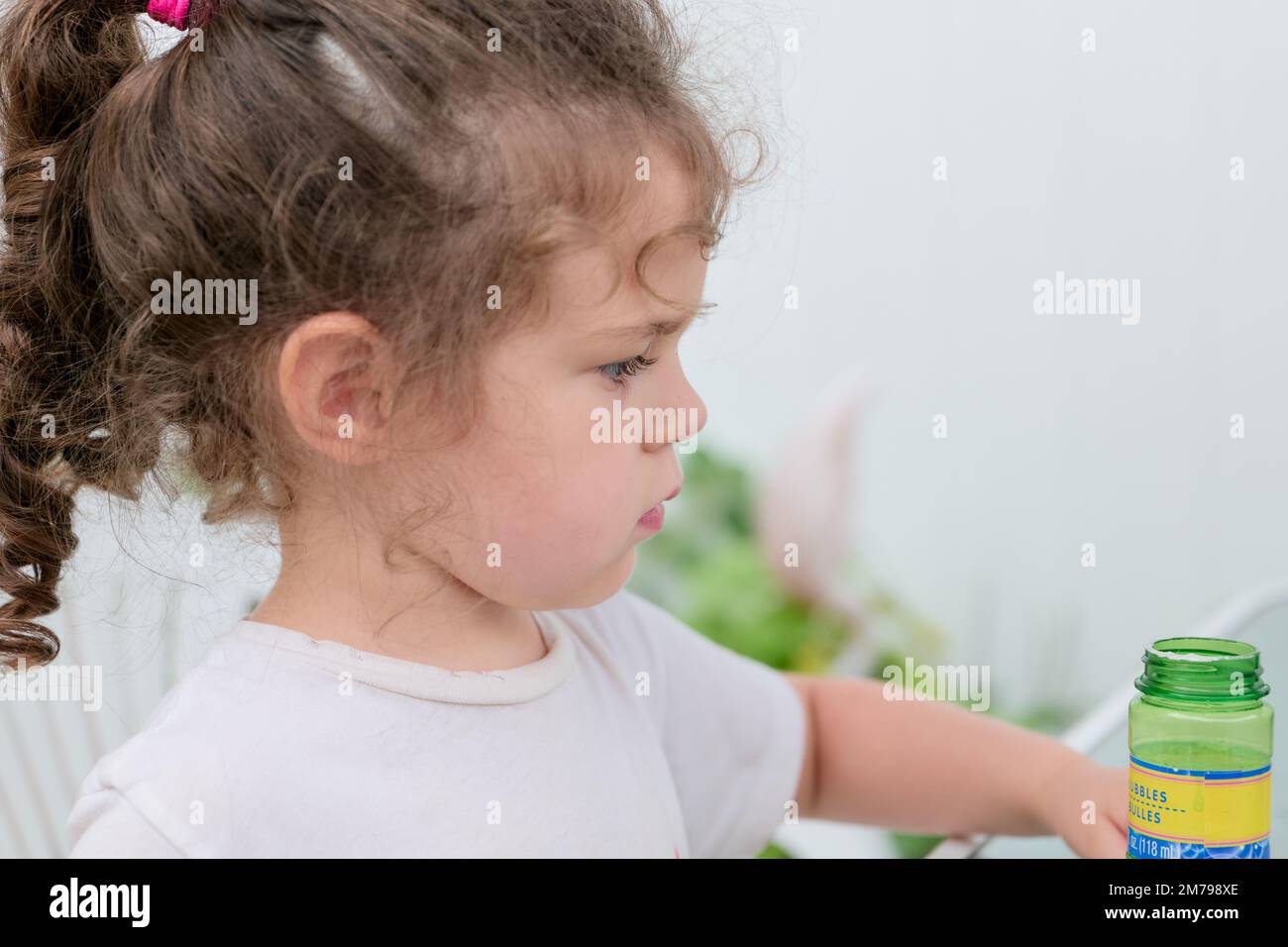 pretty young girl playing with soap bubbles in the backyard Stock Photo ...