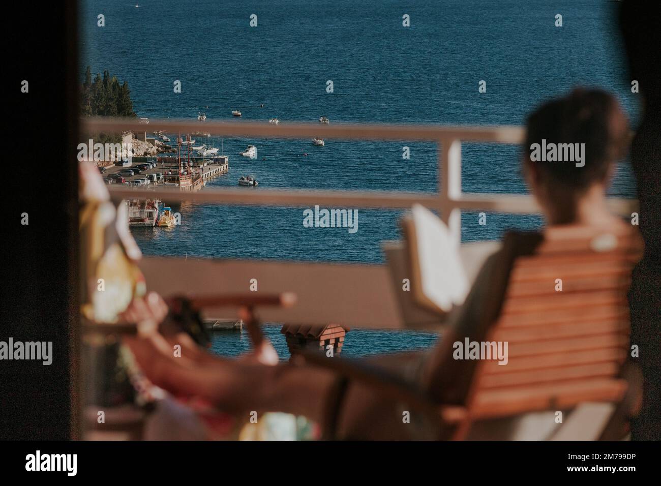 Girl from behind reading a book with an amazing view in front of her of ...