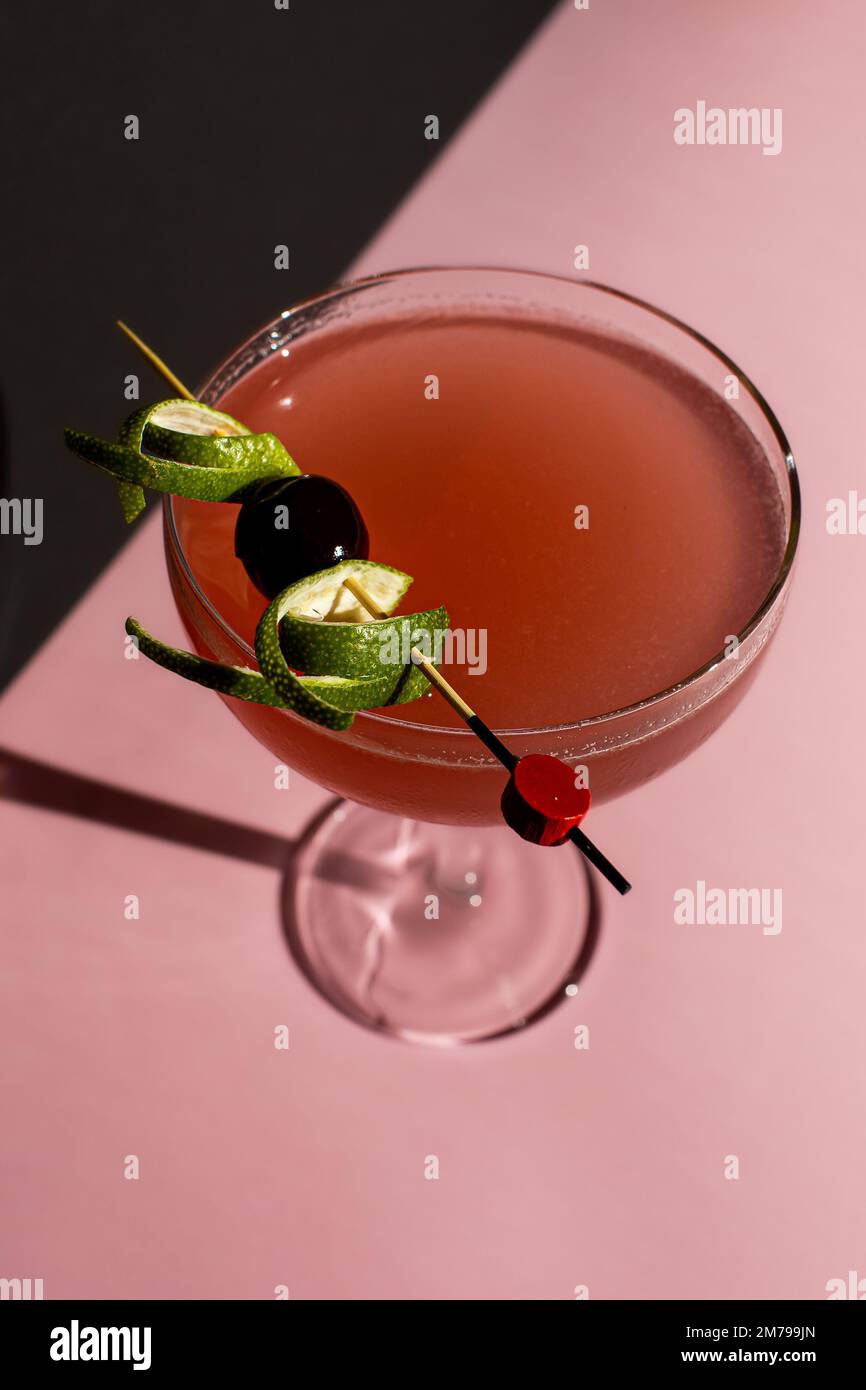 A vertical shot of a cosmopolitan cocktail with a pastel background ...