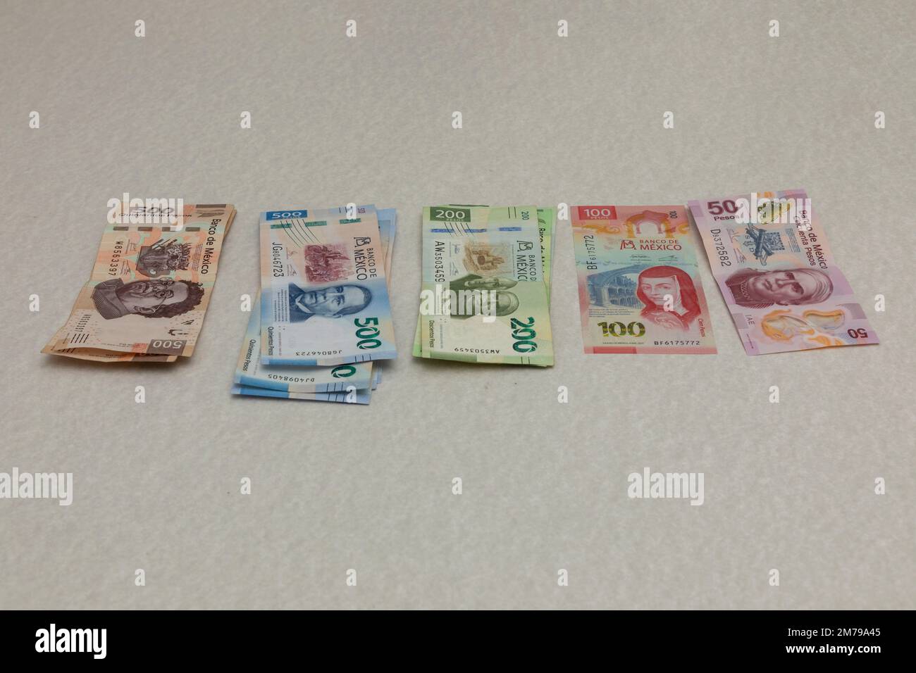 Single bills of Mexican pesos alone, on a table arranged by ...