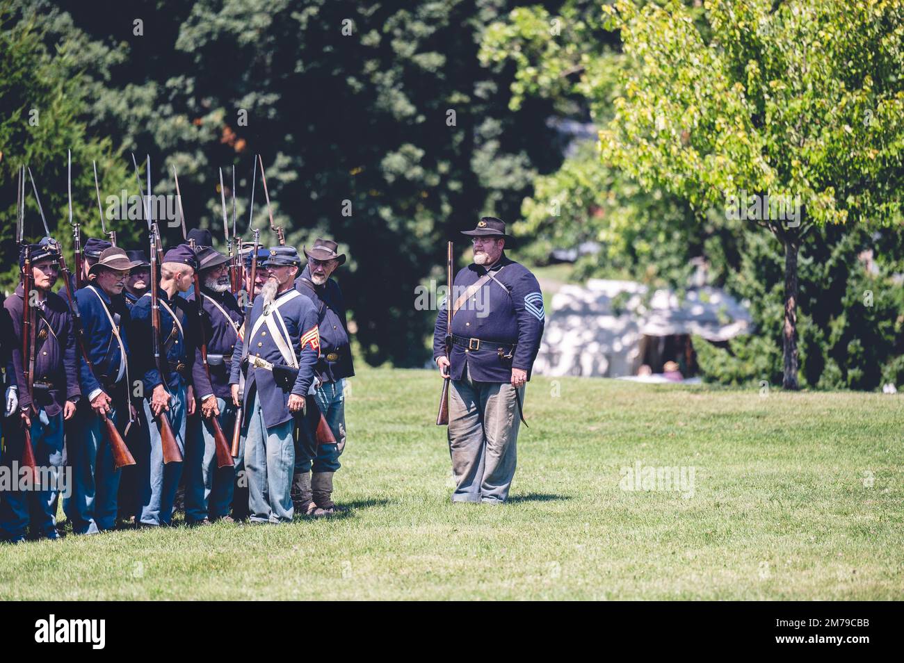 A shallow focus view of a general instructing a troop of soldiers at a ...