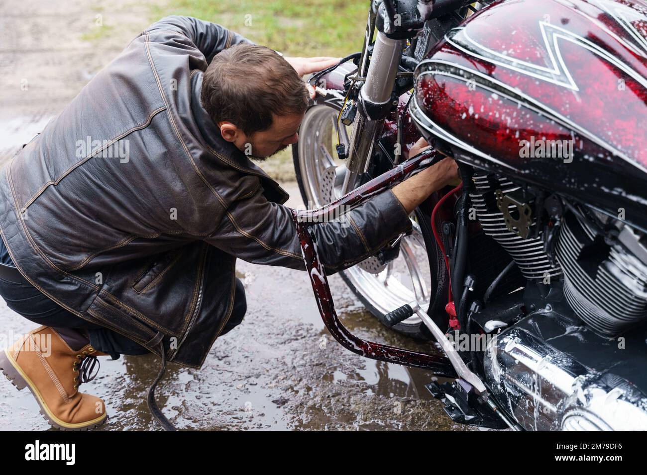 Washing a motorcycle engine with a detergent using a sponge. Close-up ...