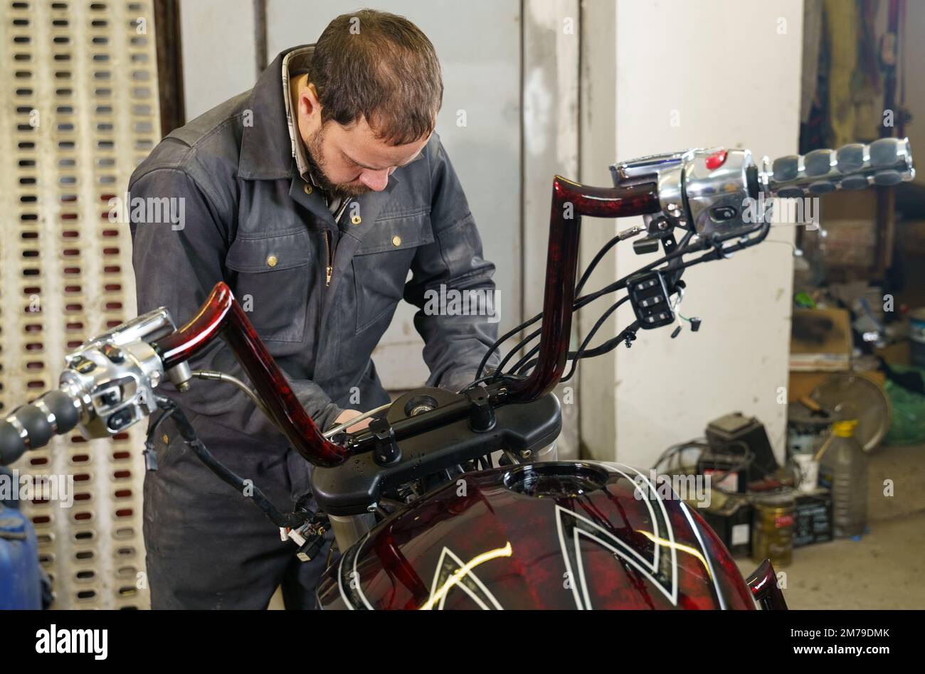 The mechanic connects the electrical cables of the motorcycle ...