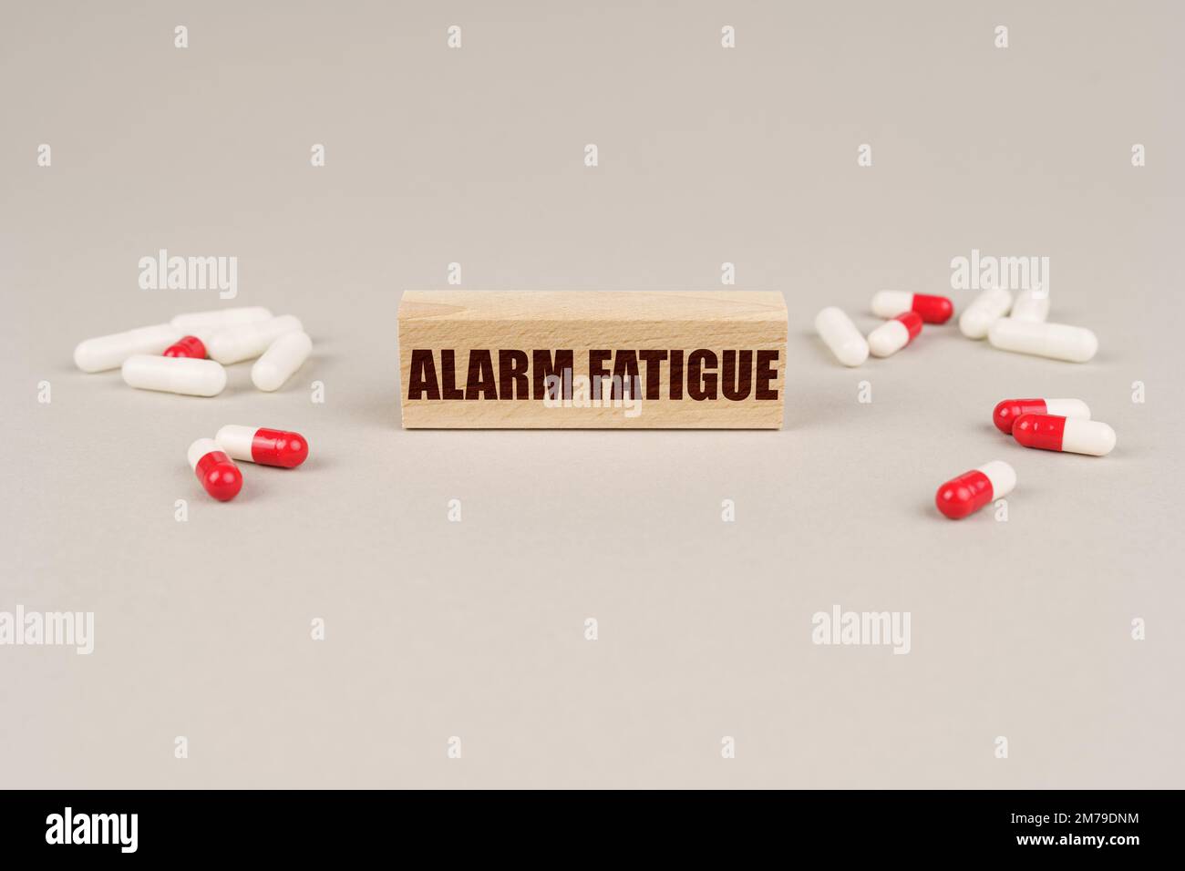 Medical concept. On a gray surface are tablets, capsules and a wooden ...