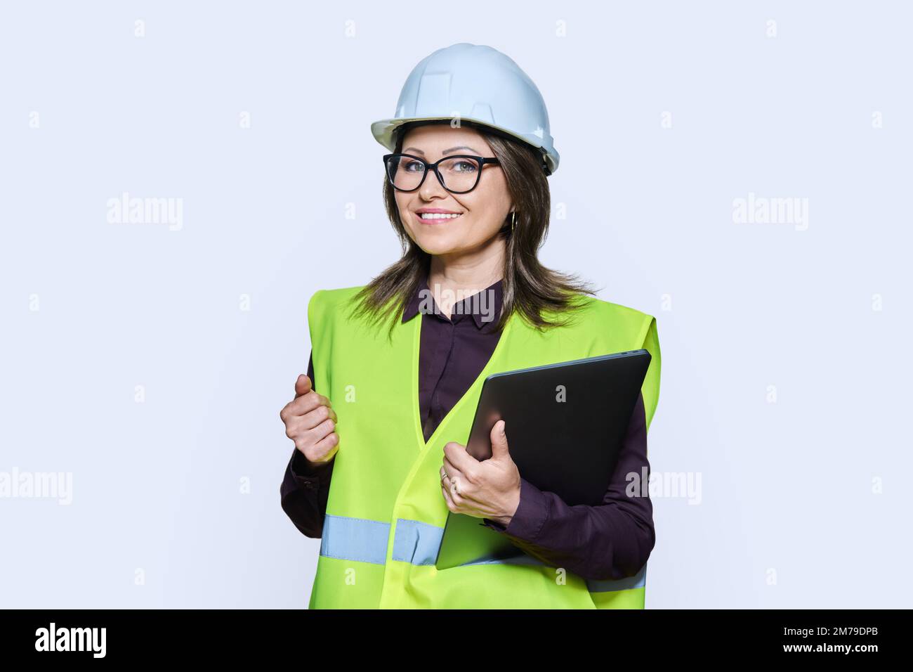 Portrait of engineer manager woman in helmet vest holding laptop Stock ...