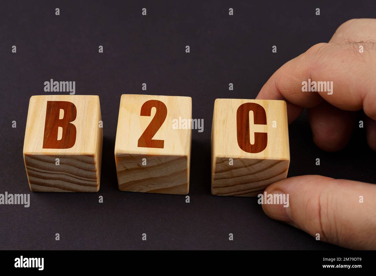 Business concept. On a black surface, a man puts cubes with the ...