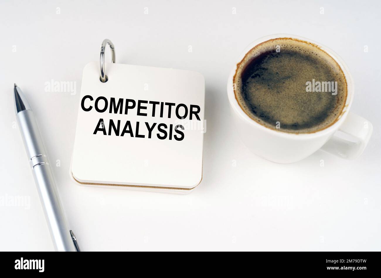 Business concept. On a white surface, a cup of coffee, a pen and a ...