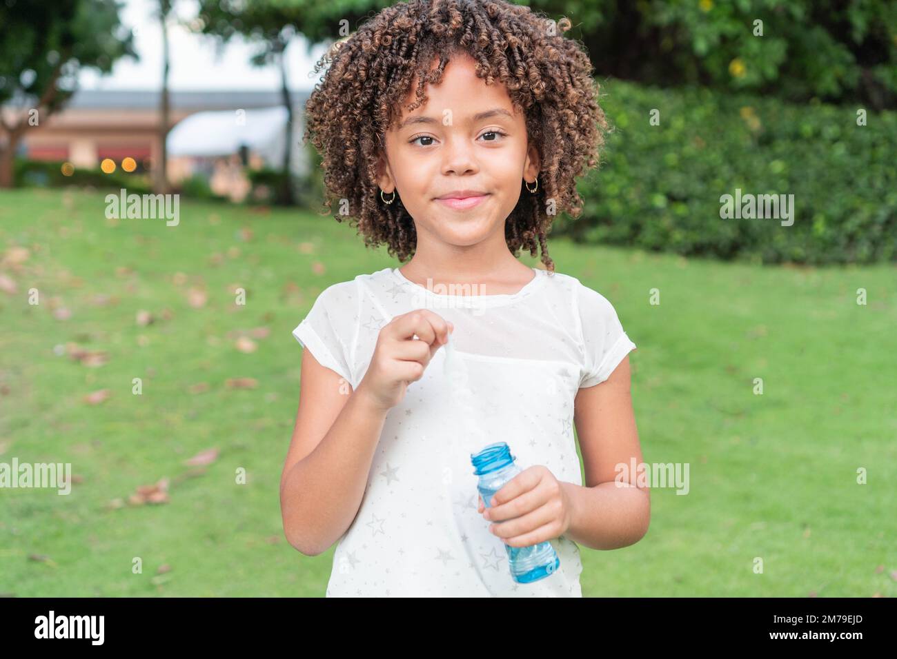 Latin Little girl playing with bubbles Stock Photo - Alamy
