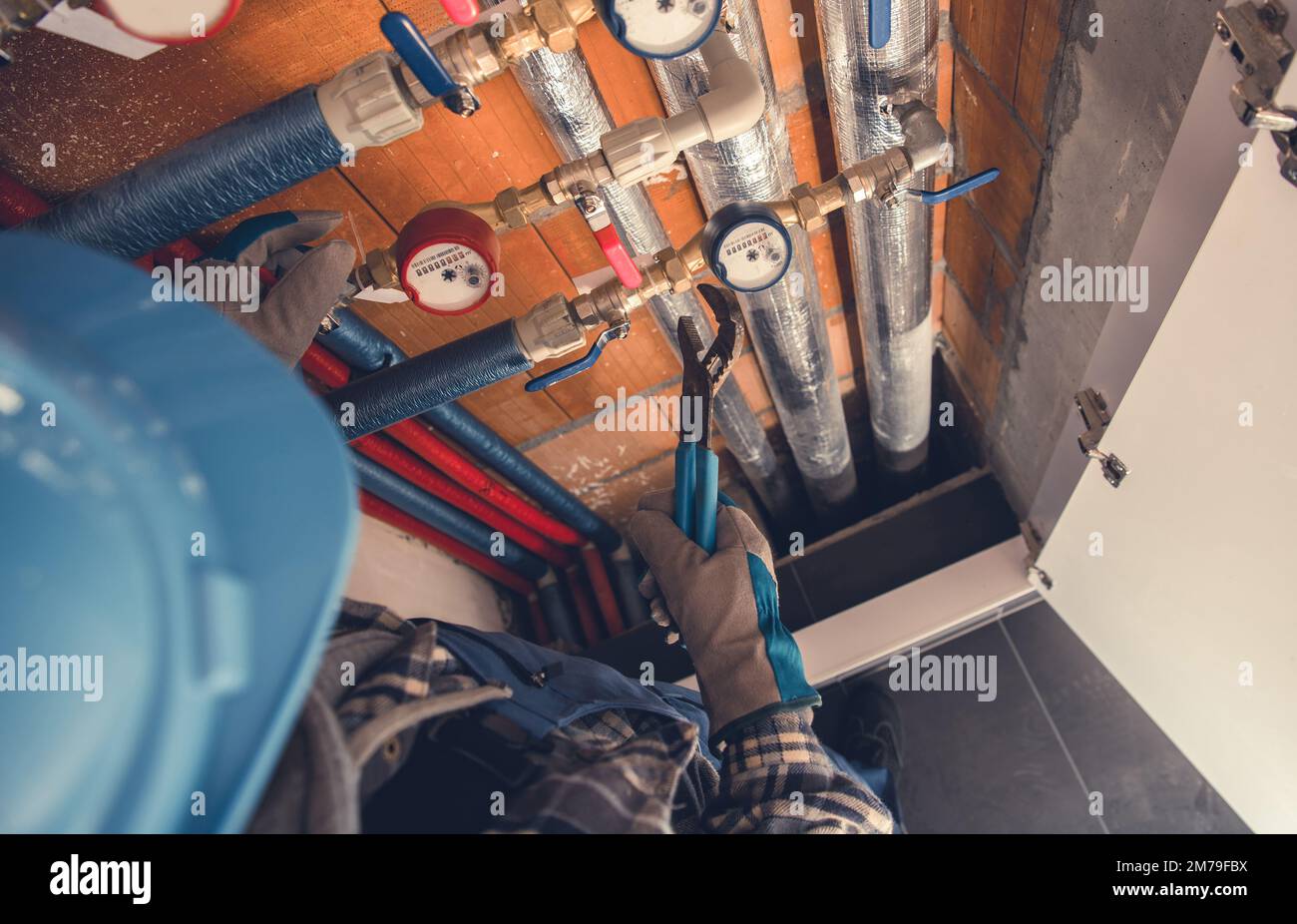 Aerial View of Plumber with Hydraulic Key Performing Hot and Cold Water ...