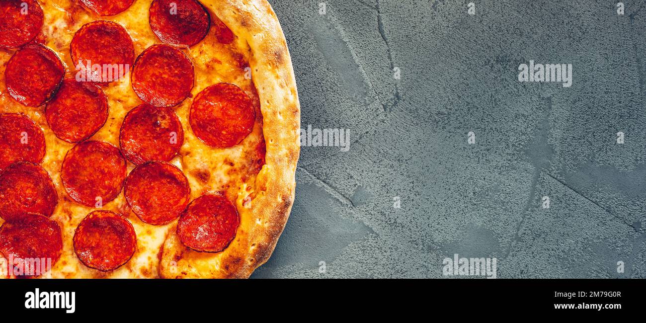Pepperoni pizza on a gray concrete background Stock Photo - Alamy