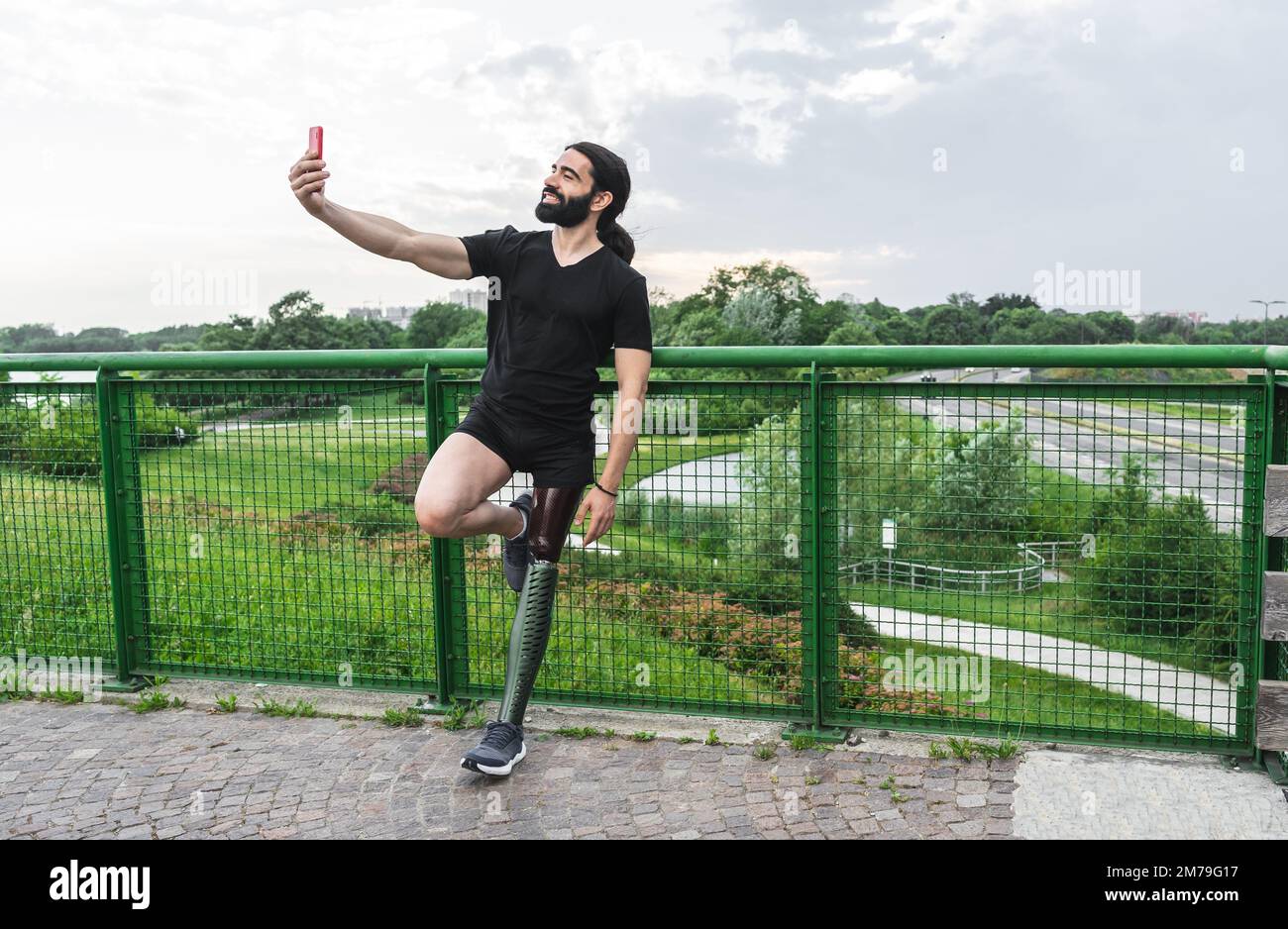 Hispanic man with prosthetic leg taking selfie after workout routine ...