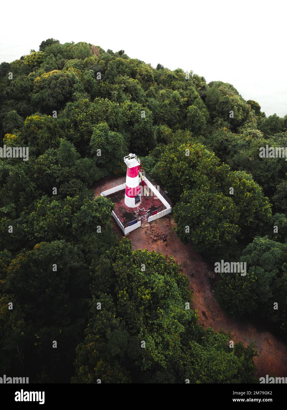 An aerial view of a lighthouse in the middle of dense forests Stock ...