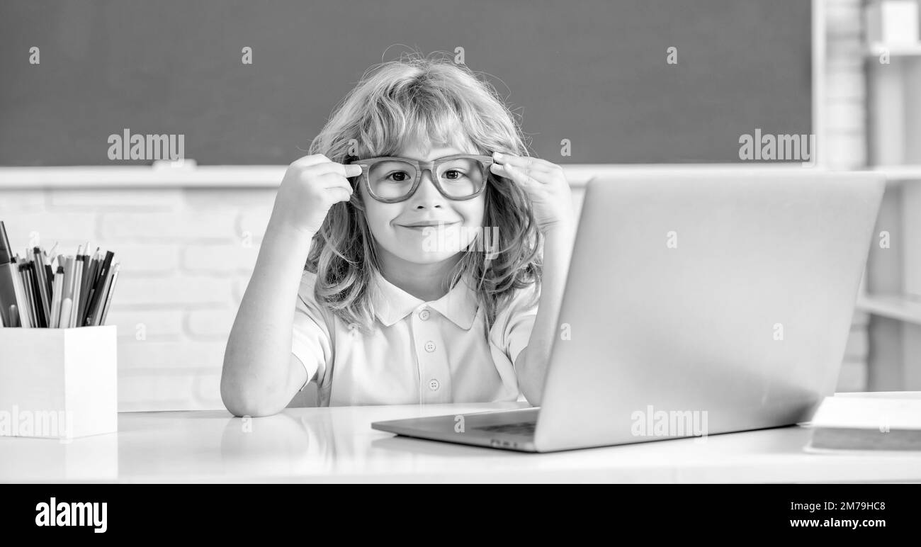 cheerful kid boy in glasses study online in school classrrom with ...