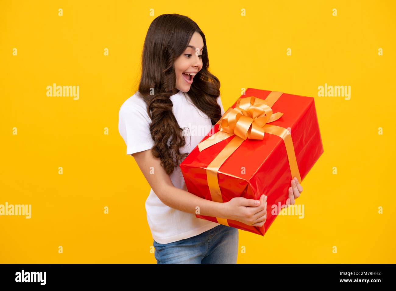 Amazed teenager. Child with gift present box on isolated background ...