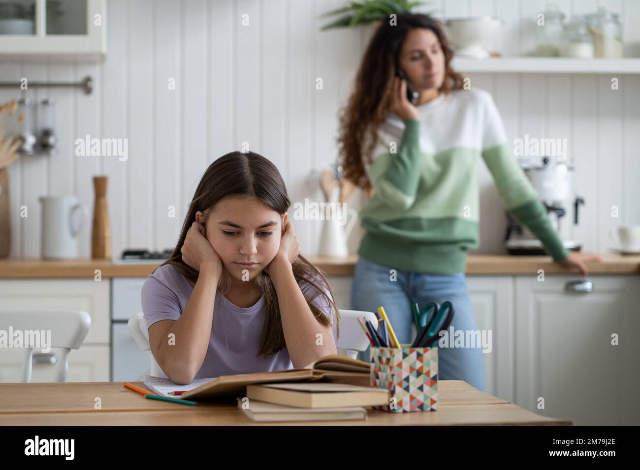 Mother does not help sad frustrated girl child with homework, kid struggling with learning at ...