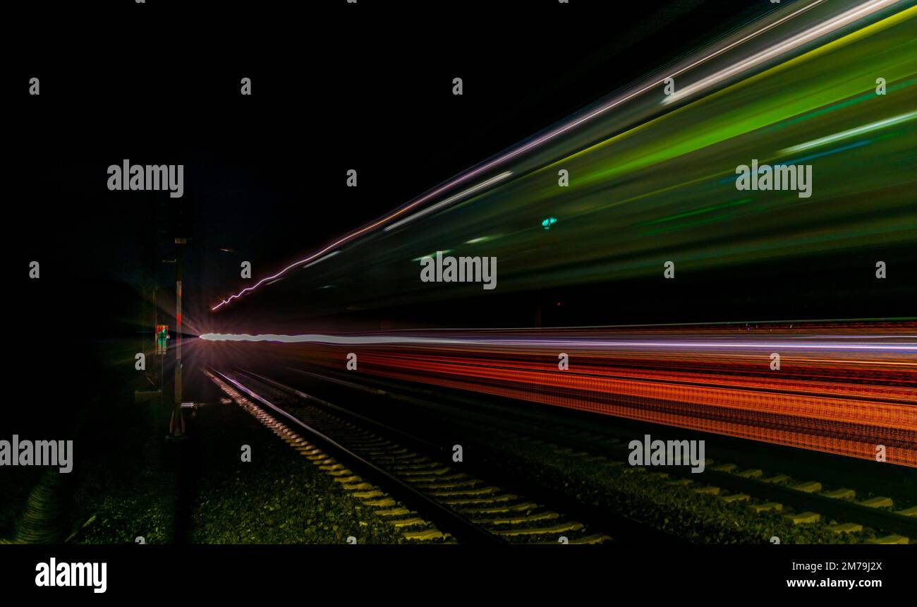 NIght dark color train lines in night between Prague and Tabor towns in ...