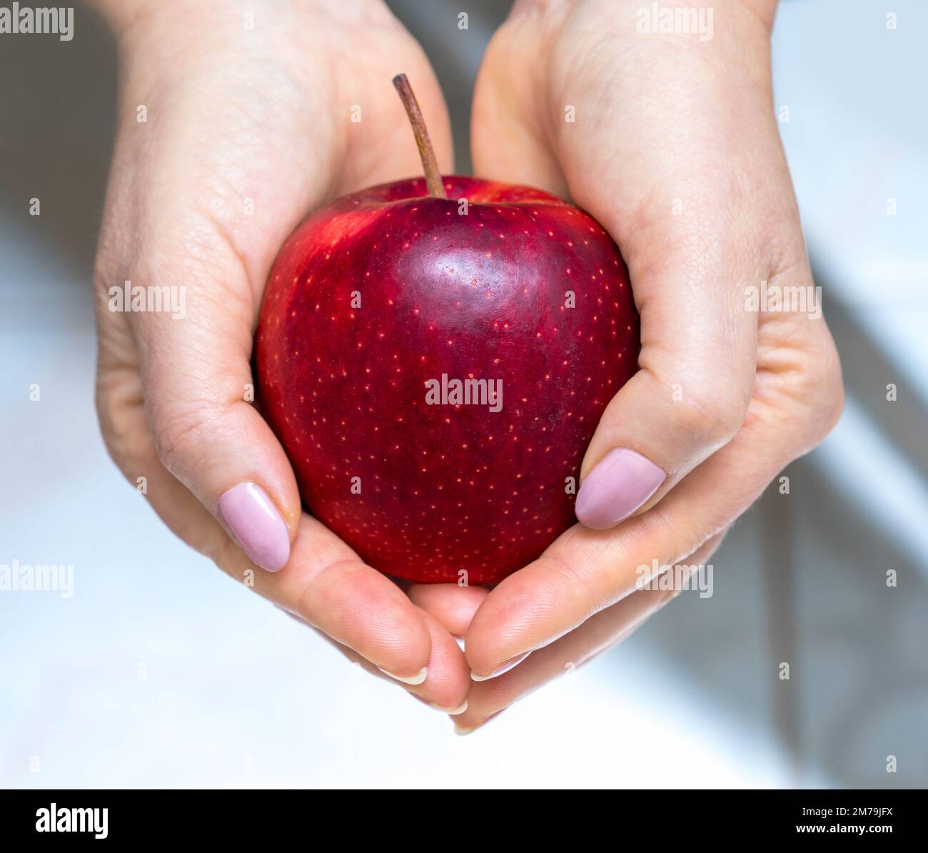 Red apple in the hands of a girl. Hallowing health Stock Photo - Alamy