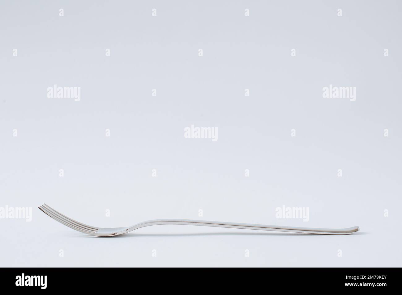 Stainless steel fork for eating on white background, kitchenware, copy ...