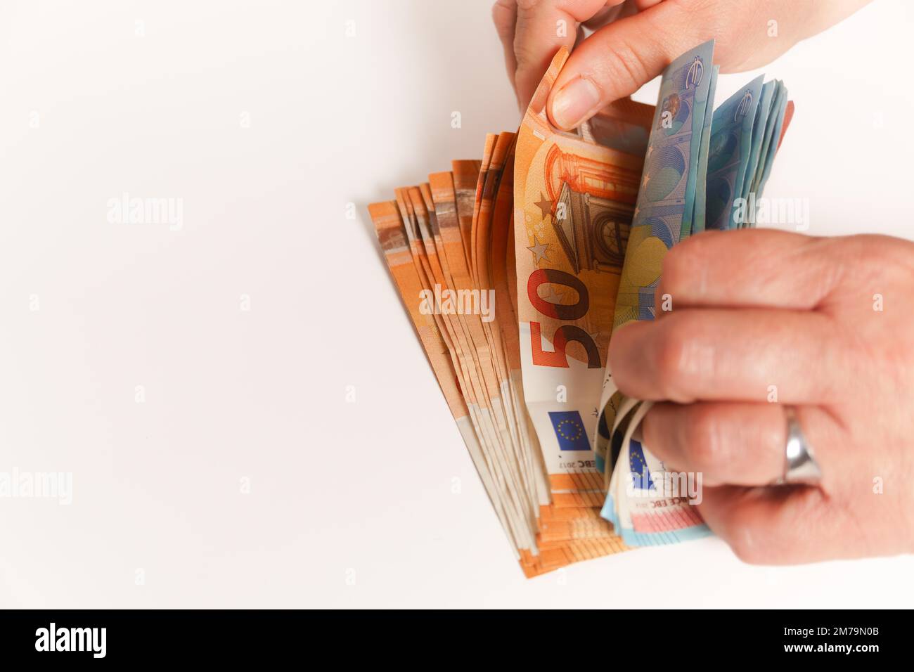 Woman counting euro banknotes on a white table with copy space Stock ...
