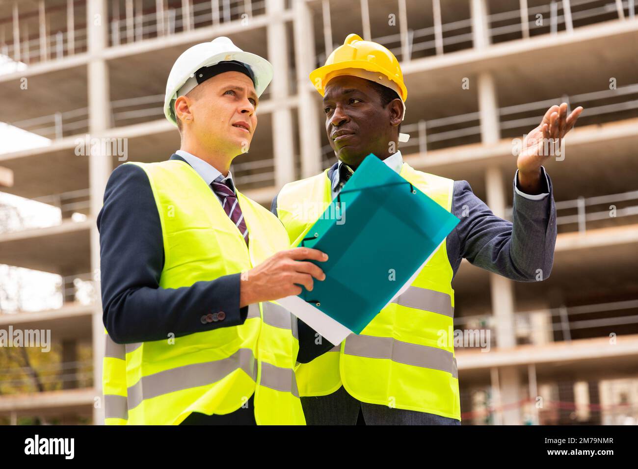 Two architect, civil engineer or building contractor colleagues on ...