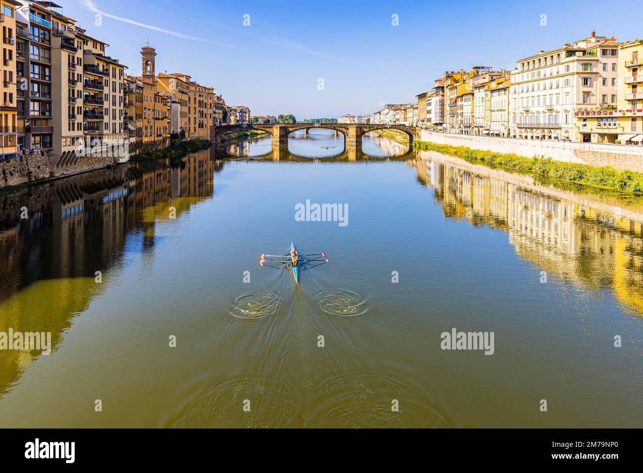 Rowers training on the river Arno, behind the Arno bridge Ponte S ...