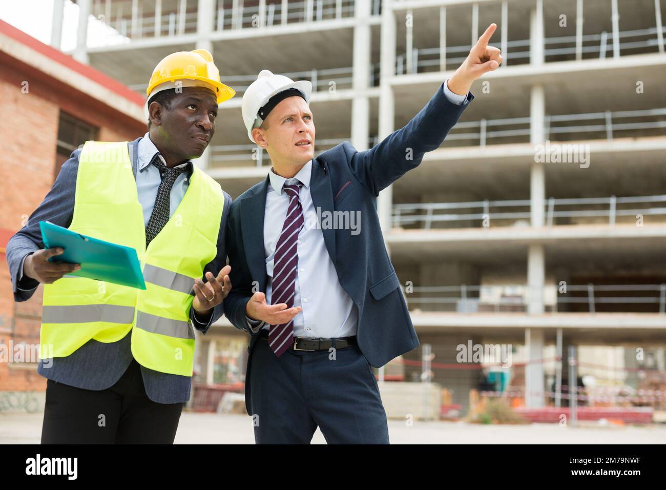 African-american architect and European engineer in warnvest discussing ...