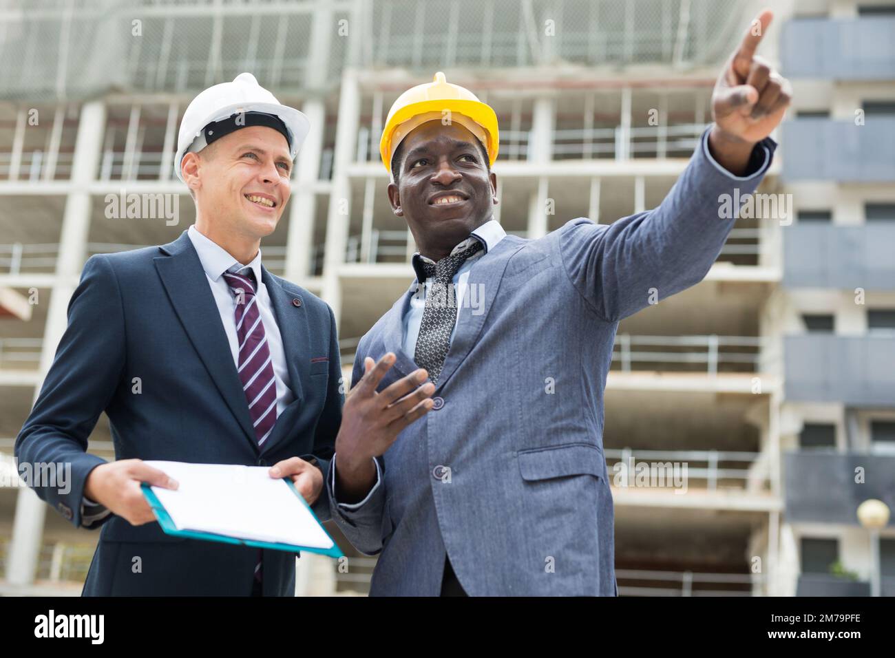 African-american architect discussing a construction plan with a ...