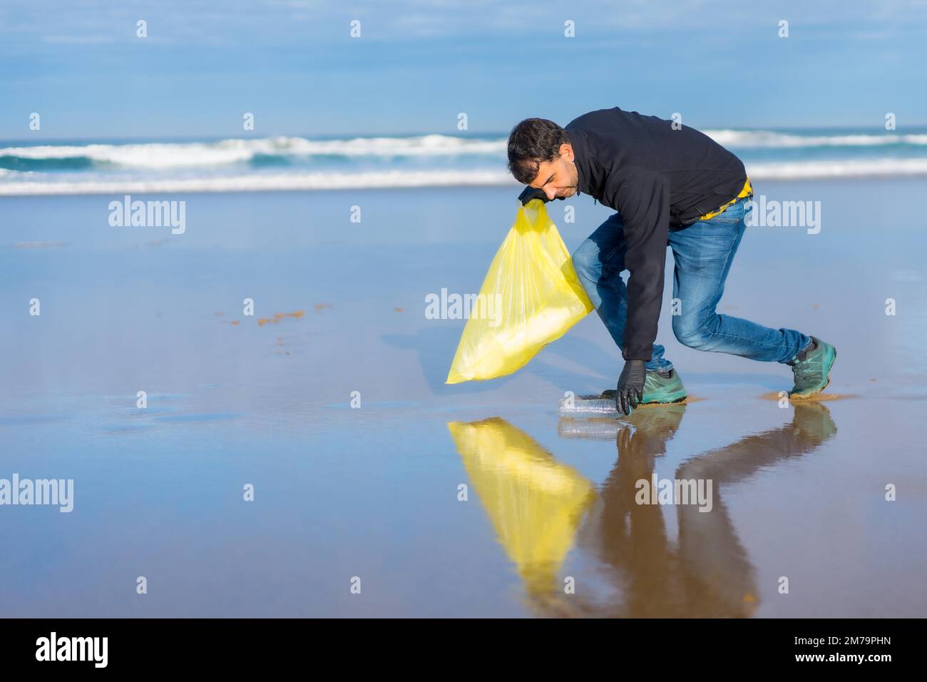 Man collecting garbage or plastic on the beach. Ecology concept, sea ...