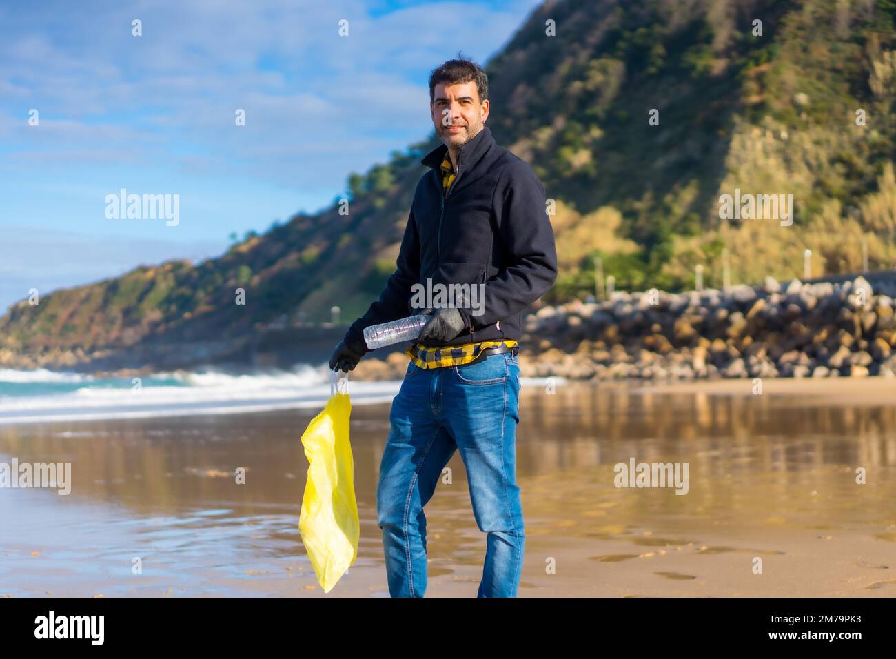 Volunteer portrait collecting garbage and plastic on the beach. Ecology ...