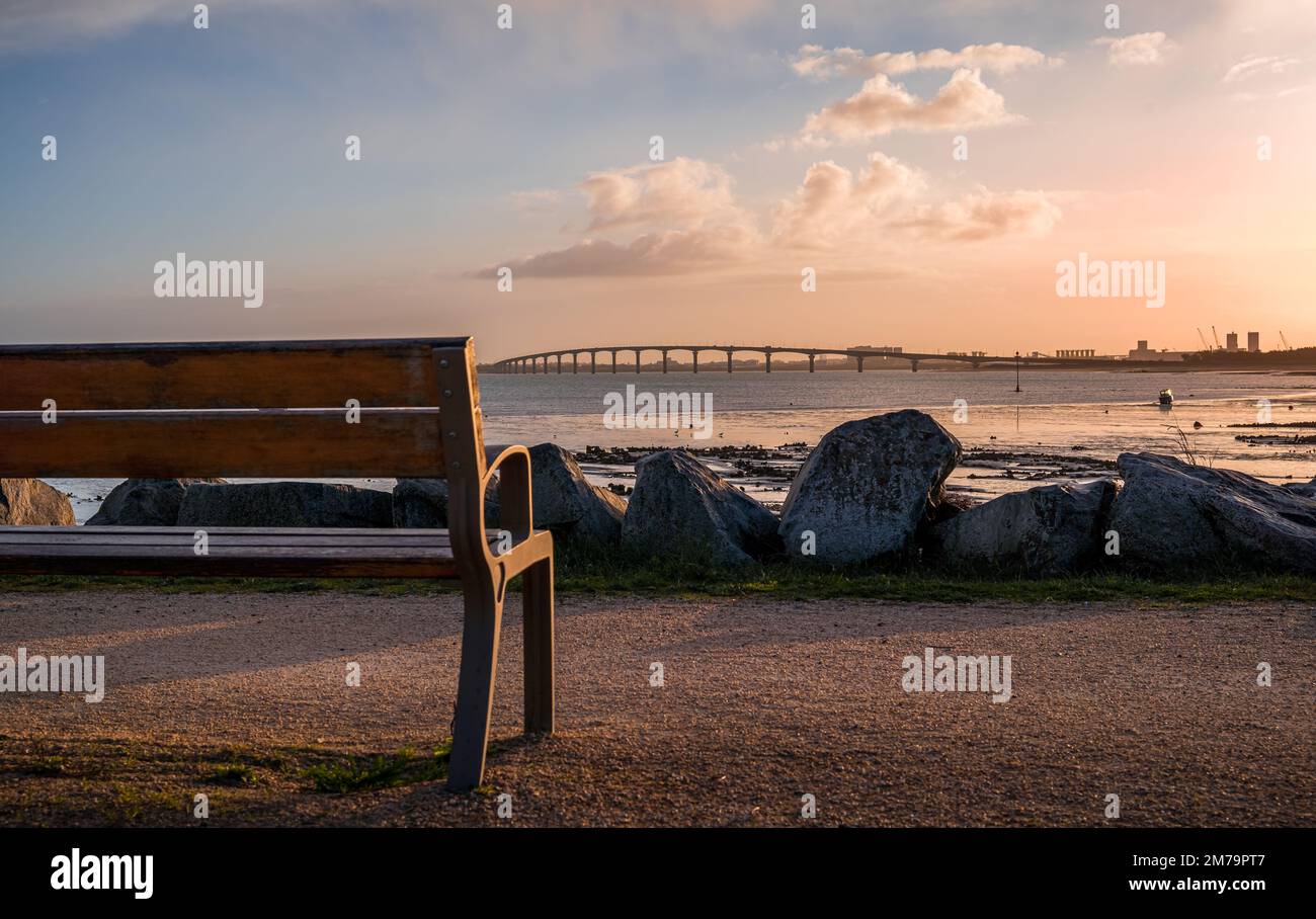 Isolated and empty public bench at sunrise. Bridge of the island of Re ...