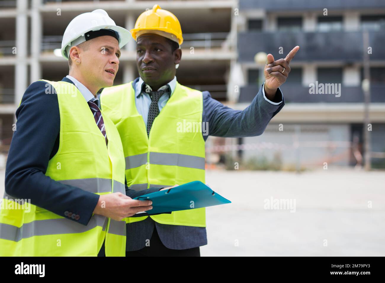 African-american engineer discussing a construction plan with a ...