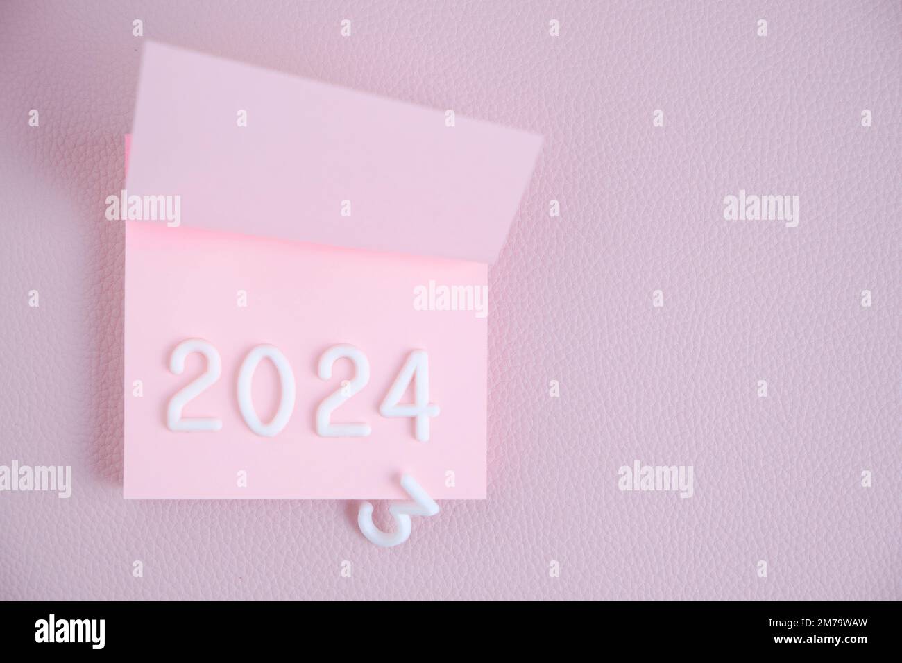 Year 2024 is laid out in white numbers pink sheet.Concept time and new ...