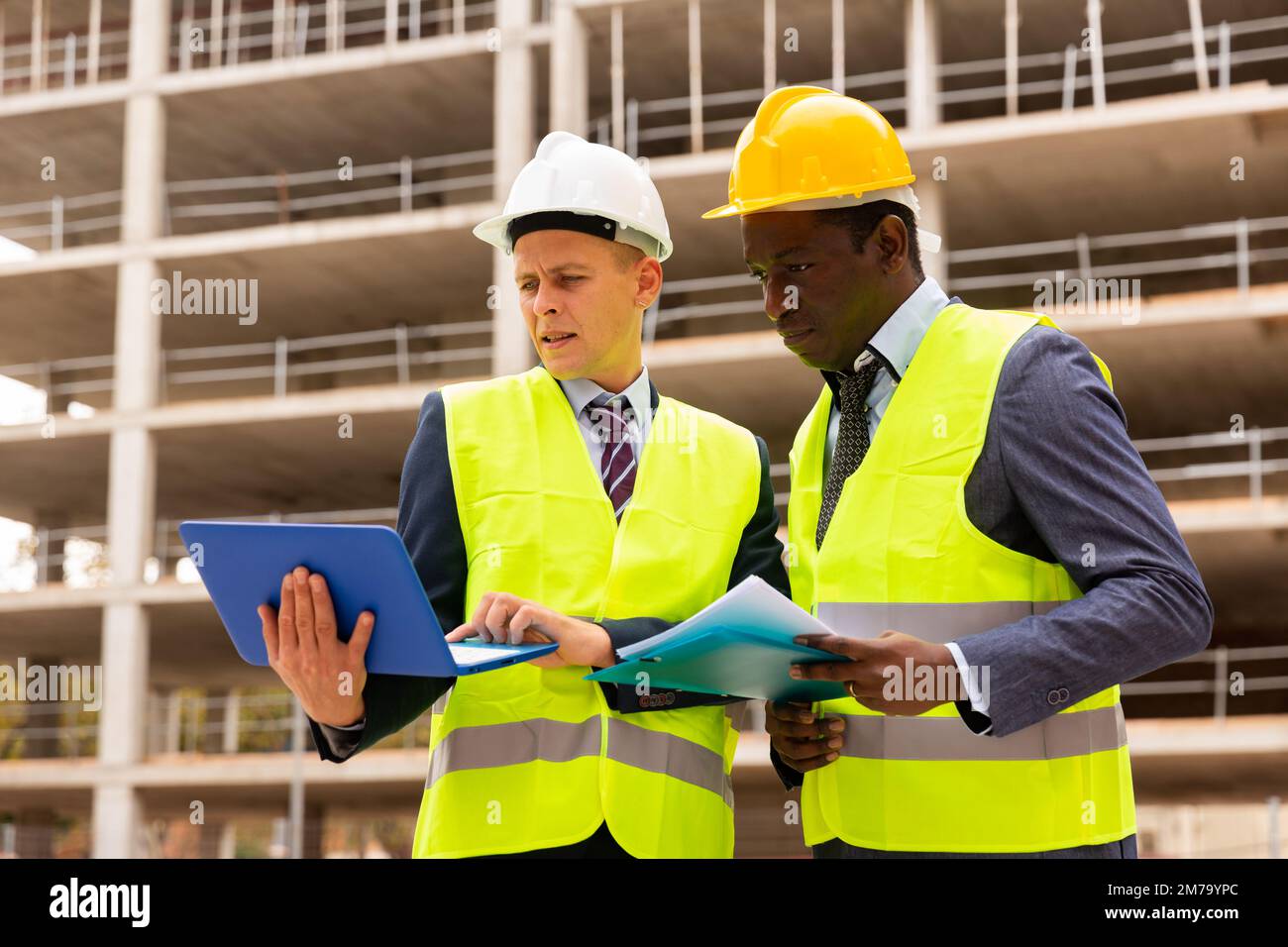 Two civil engineers controls the progress of work on a laptop Stock ...