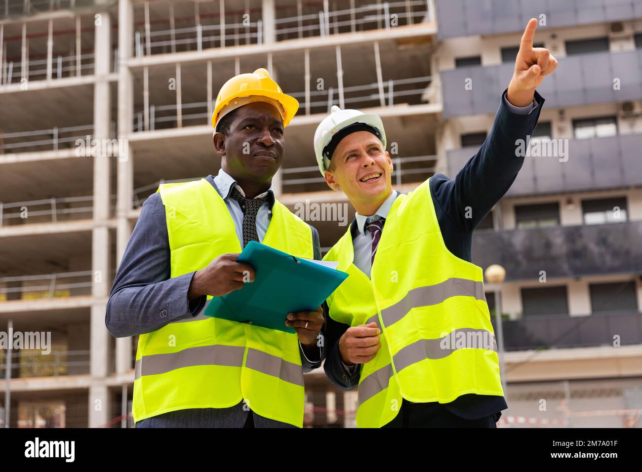 Positive architect and contractor having brief meeting on construction ...